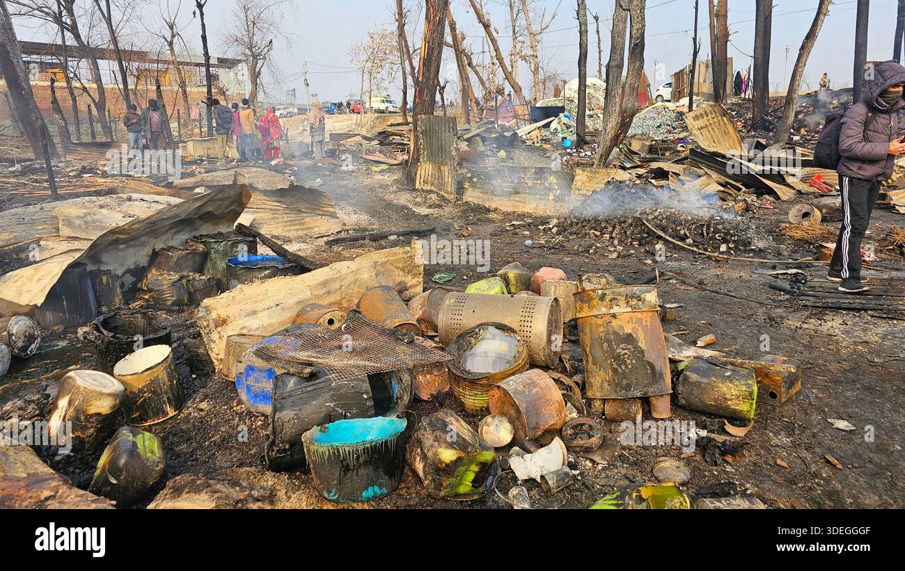 People try to salvage belongings from the charred remains after a fire ...