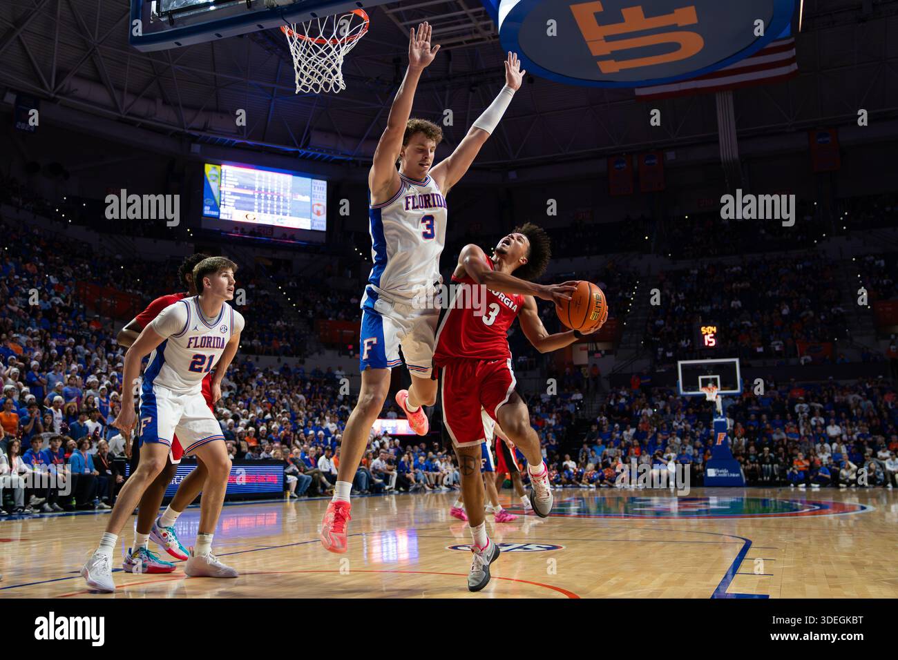 Florida center Micah Handlogten (left) jumps to guard Georgia guard ...