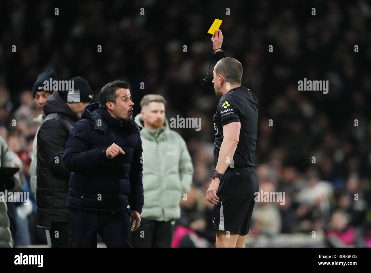 Referee Peter Banks shows the yellow card to Fulham's head coach Marco ...