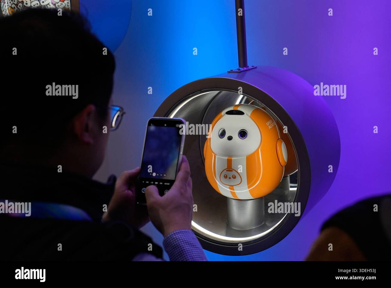 A person checks out an AiMe AI robot on display at the TCL booth during ...