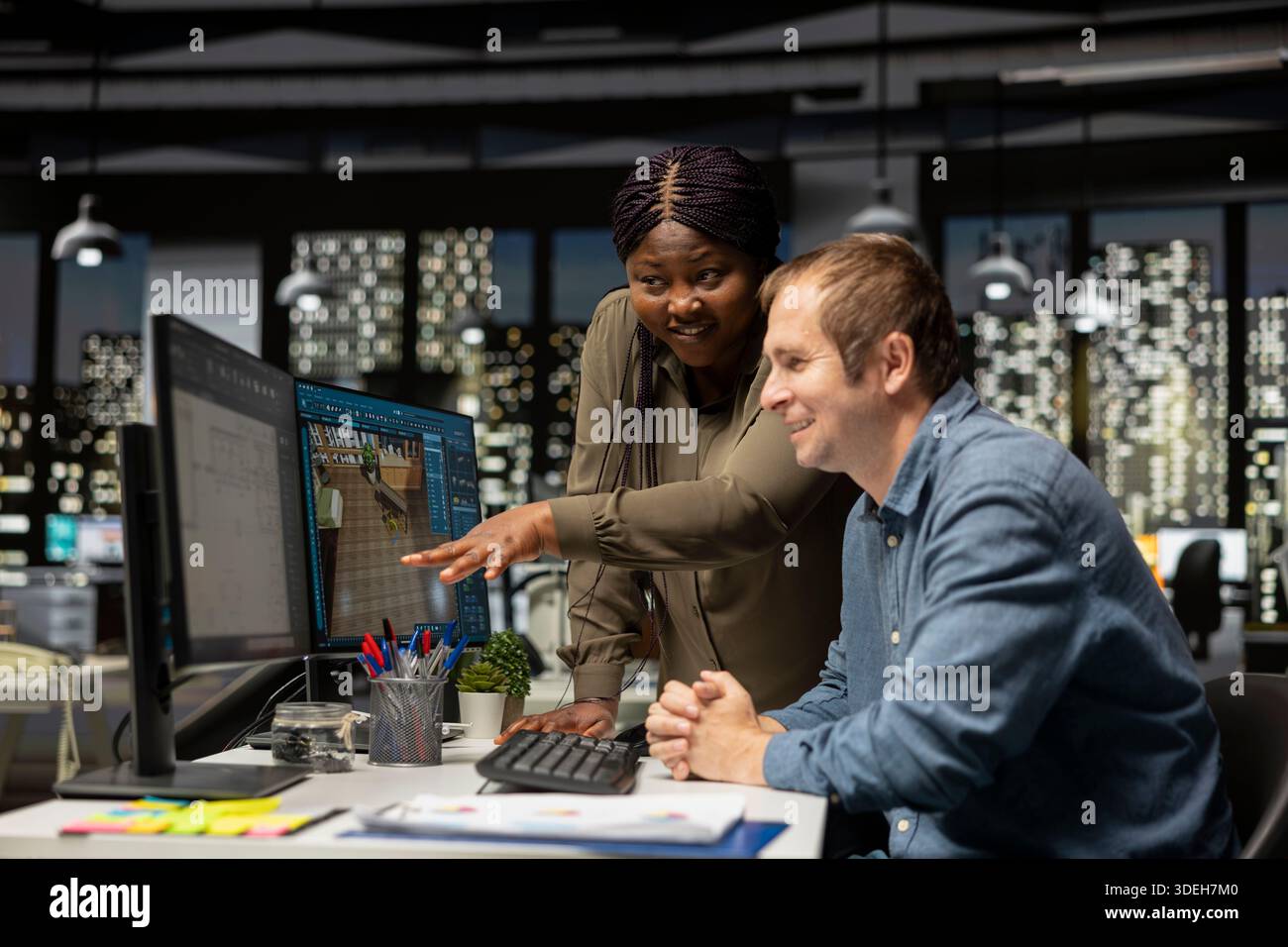 Diverse engineering team designing a floor plan on dual monitors, using ...