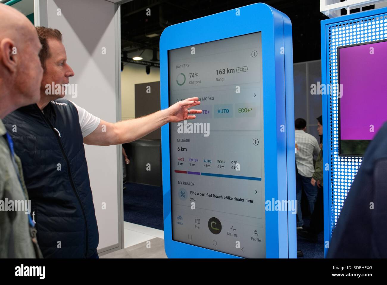 People look at a display of the Bosch eBike Flow app at the Bosch booth ...