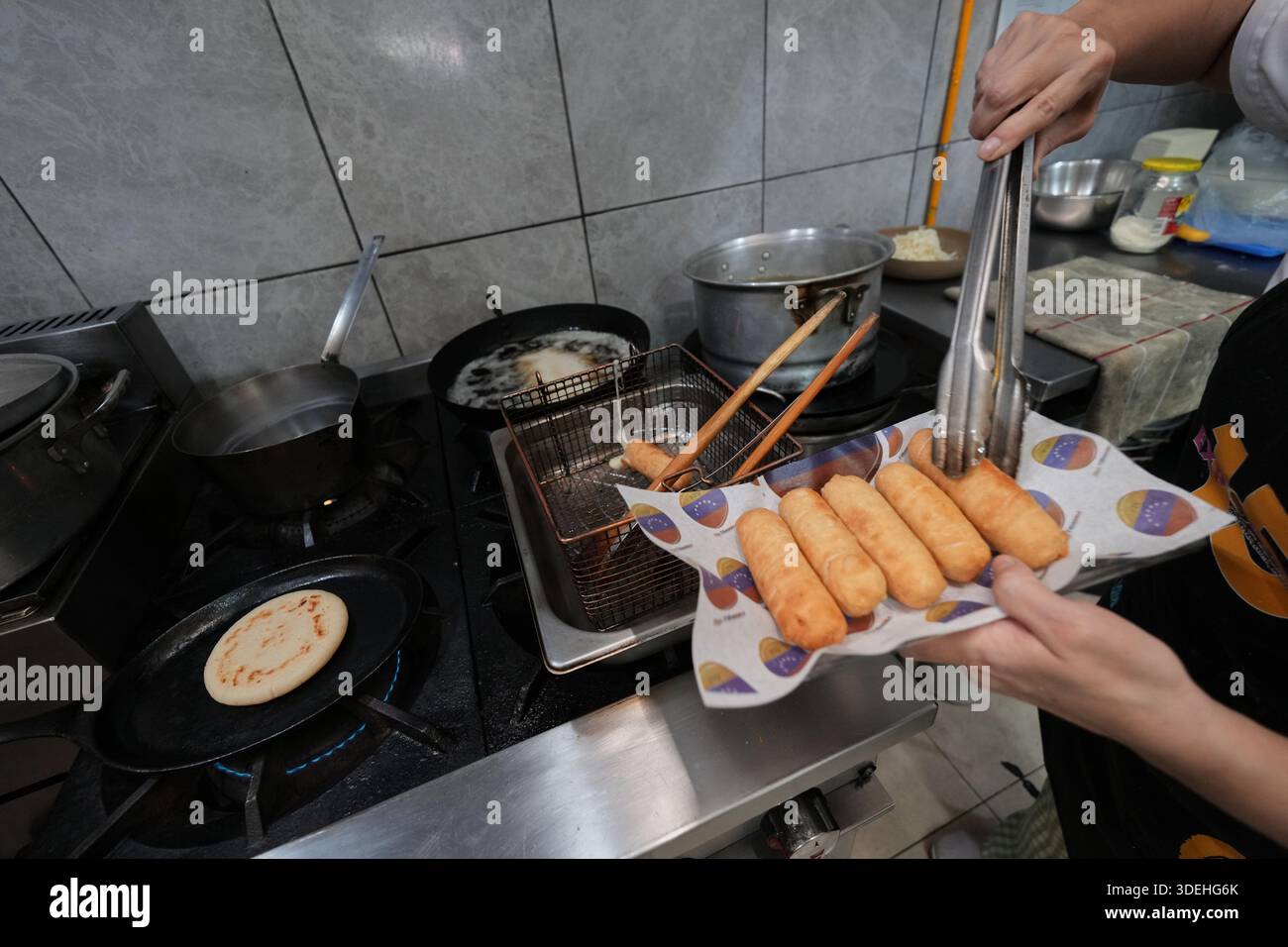 A Venezuelan migrant prepares "tequeños," a typical Venezuelan food, at ...