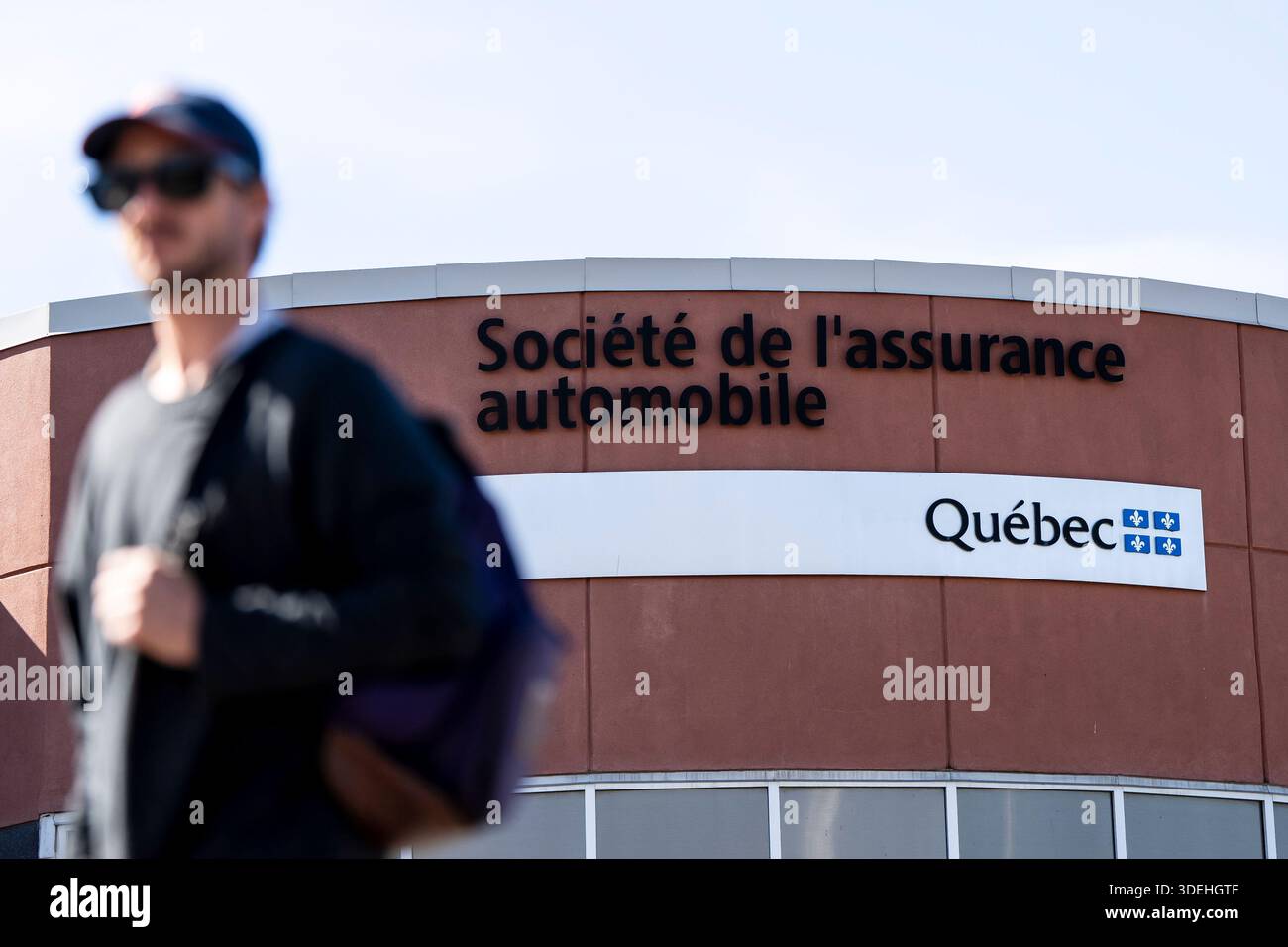 Une personne passe devant un bureau de la Société de l'assurance ...