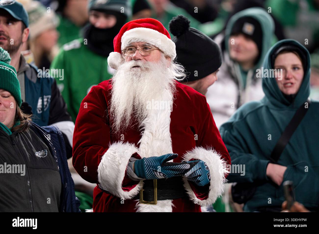 A fan dressed as Santa Claus looks on from the stands during an NFL ...