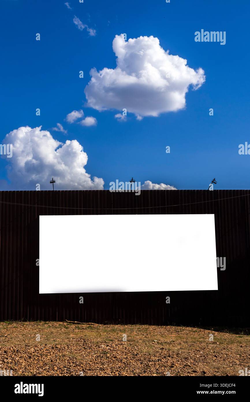 Billboard with a blank screen in steel wall background, on a sunny day ...