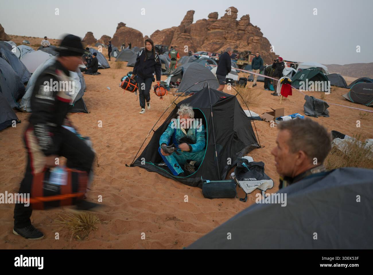 Drivers and co-drivers pack up their tents before the start of the ...