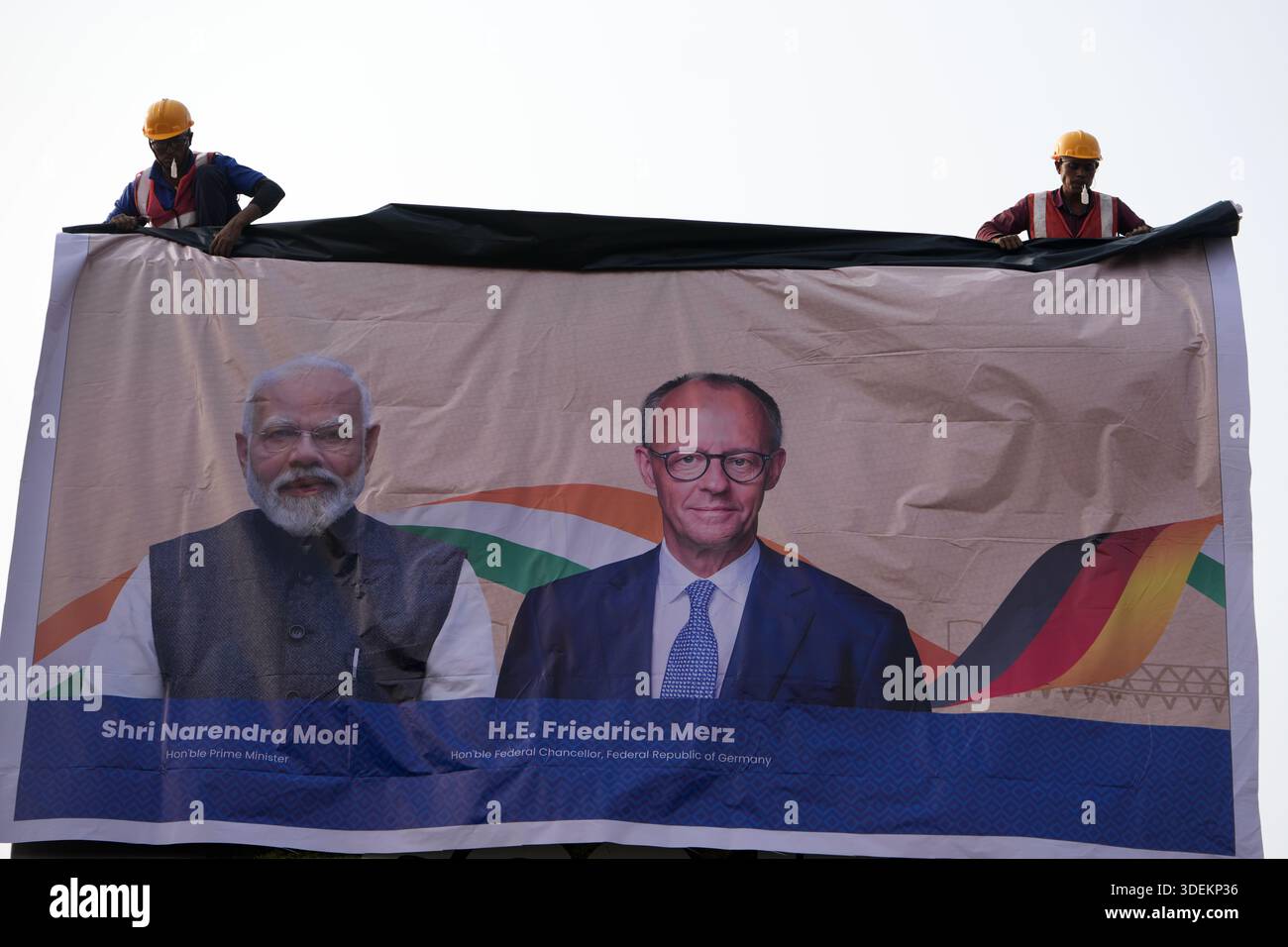 Workers install a hoarding welcoming German Chancellor Friedrich Merz ...