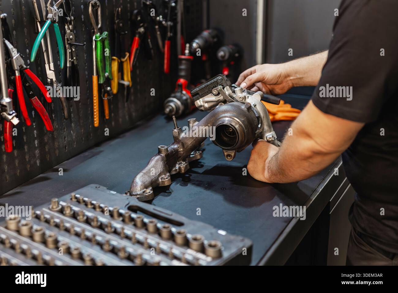 Mechanic repairing or replacing the turbocharger in the engine bay ...