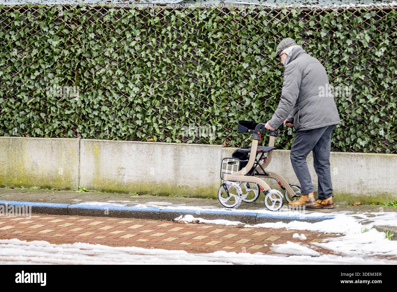 HOOFDDORP - An old man with a walker walks through the snow ROBIN ...