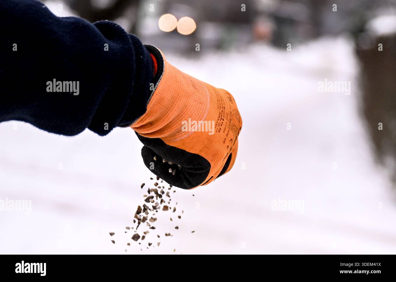 08 January 2026, Berlin: A young man is gritting the sidewalk in front ...