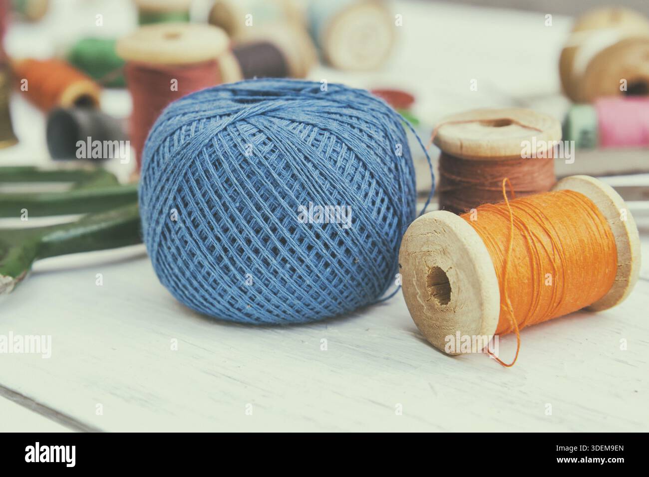 Set of several pied garment threads on a bright wooden background ...