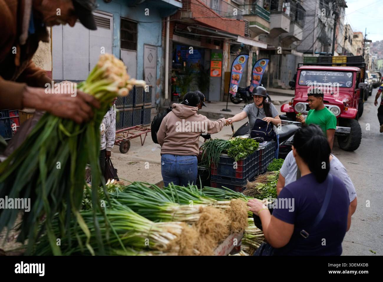 Shoppers buy vegetables at a street market in Caracas, Venezuela ...