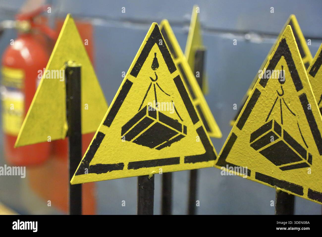 Caution. Lifting and moving heavy goods. Yellow triangular warning sign ...