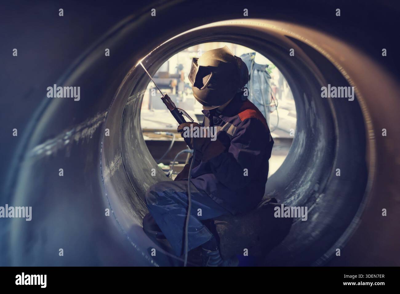 Welder is repairing the defective area of the weld inside the parts of ...