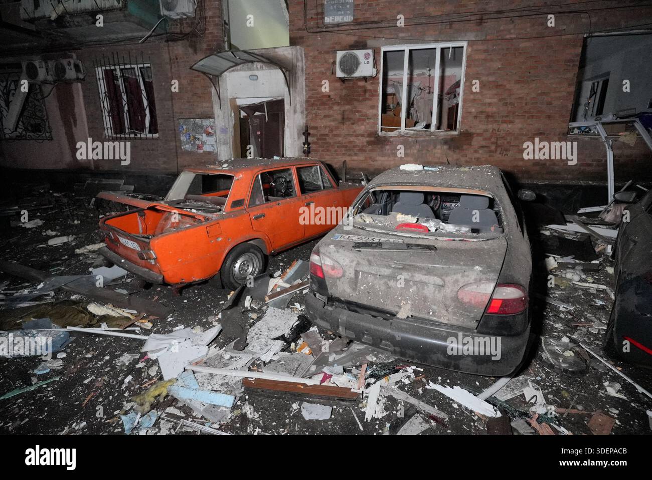 Cars damaged during a Russian strike sit parked amid debris in Kryvyi ...
