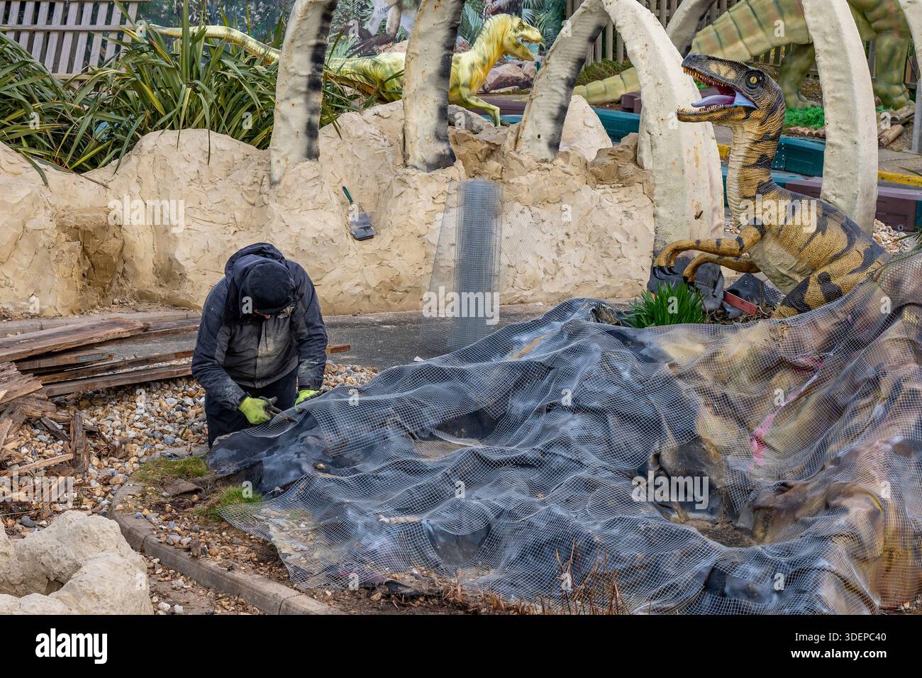 Workman repairing scenery at a fairground ride at the Needles theme ...