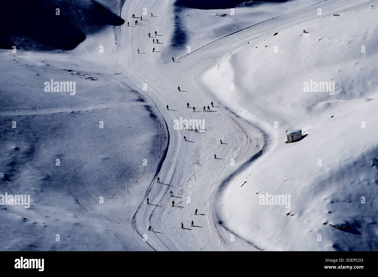 FILE - Skiers cast long shadows as they glide down a slope at the Mzaar ...