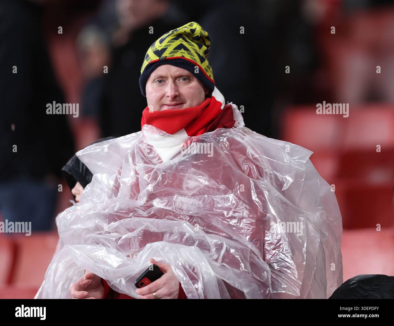 London, England, 8th January 2026. An Arsenal fans takes cover from the ...