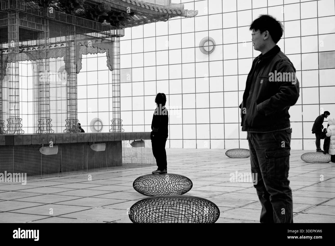 Visitors interact with wire-mesh sculptures and a lattice-walled ...