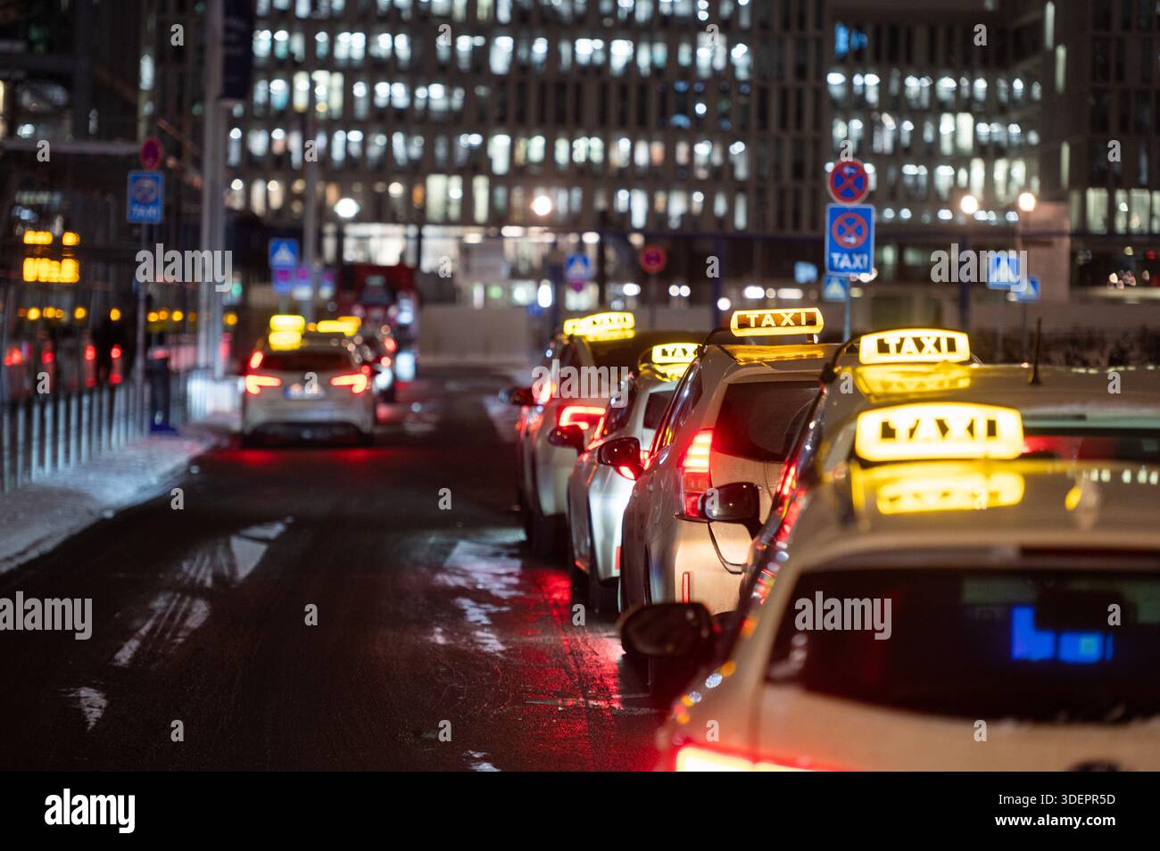 08 January 2026, Berlin: Cabs wait for passengers in front of the main ...