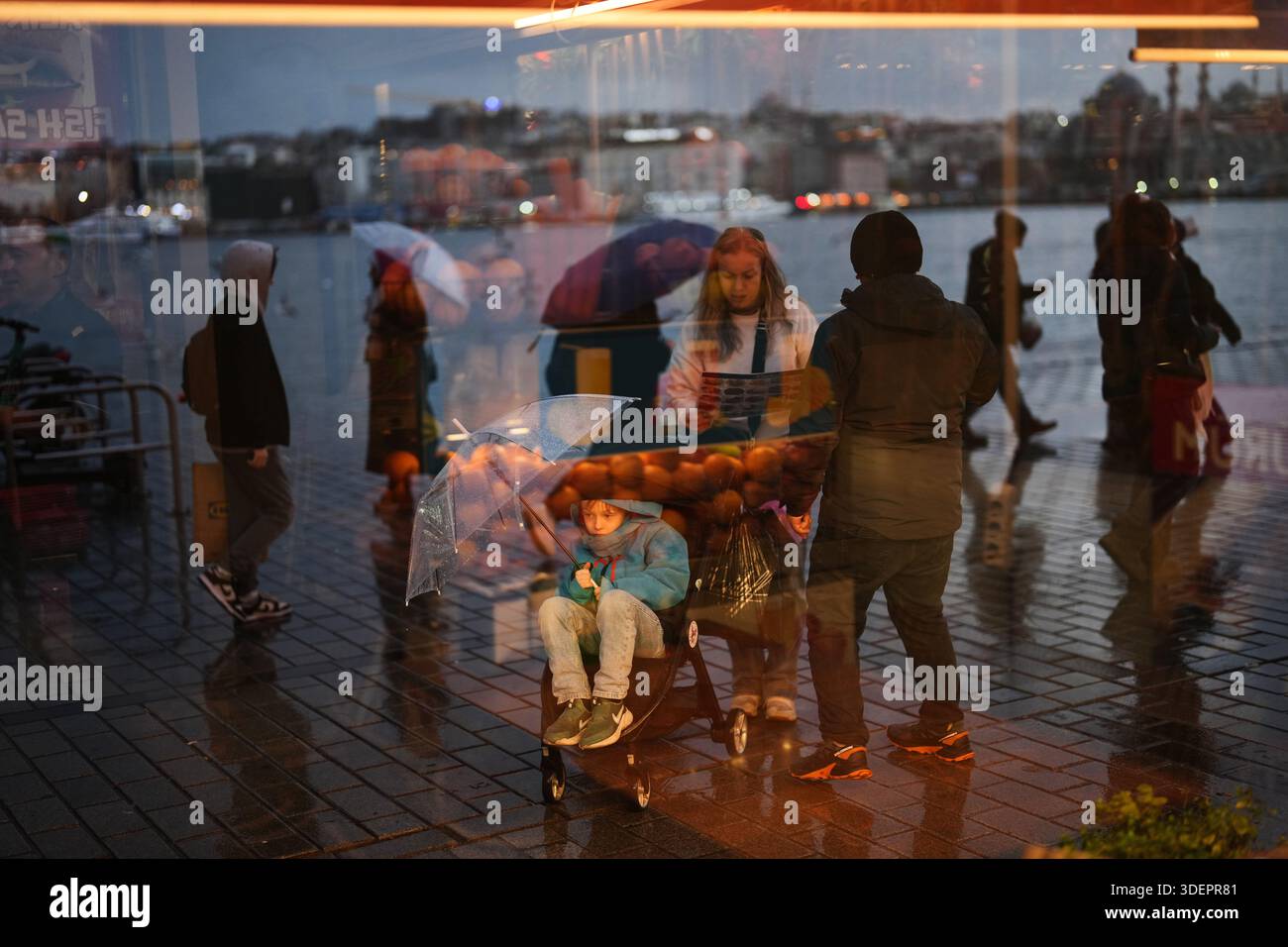 A child holds an umbrella during a rainy winter day in Istanbul, Turkey ...
