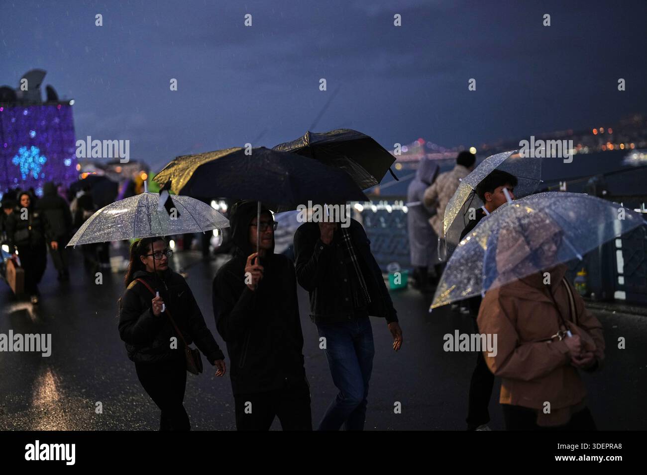 Pedestrians equipped with umbrellas walk by on a rainy winter day in ...