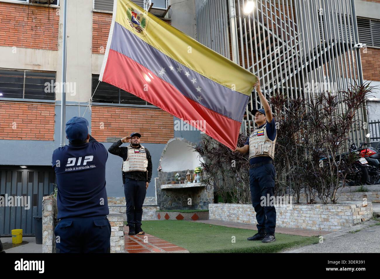 Police officers lower a flag at Zone 7 of the Bolivarian National ...