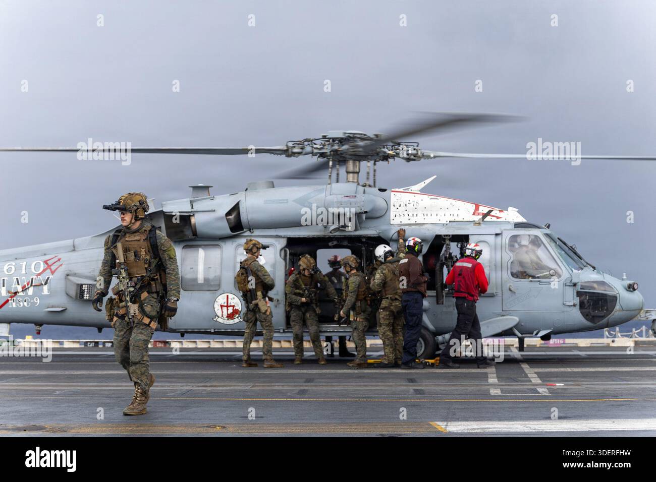 A U.S. Marine exits an MH-60S Sea Hawk helicopter, attached to ...