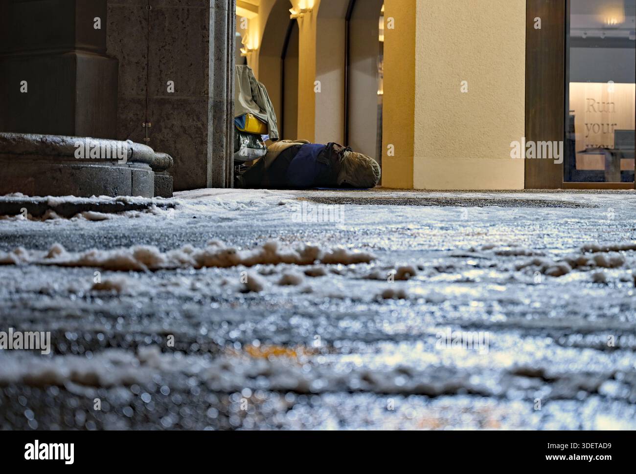 Munich, Germany. 09th Jan, 2026. A person lies wrapped up in jackets on ...