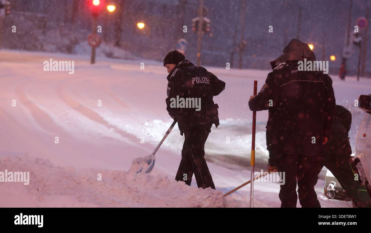 Gera, Germany. 09th Jan, 2026. Police officers shoveling snow from a ...