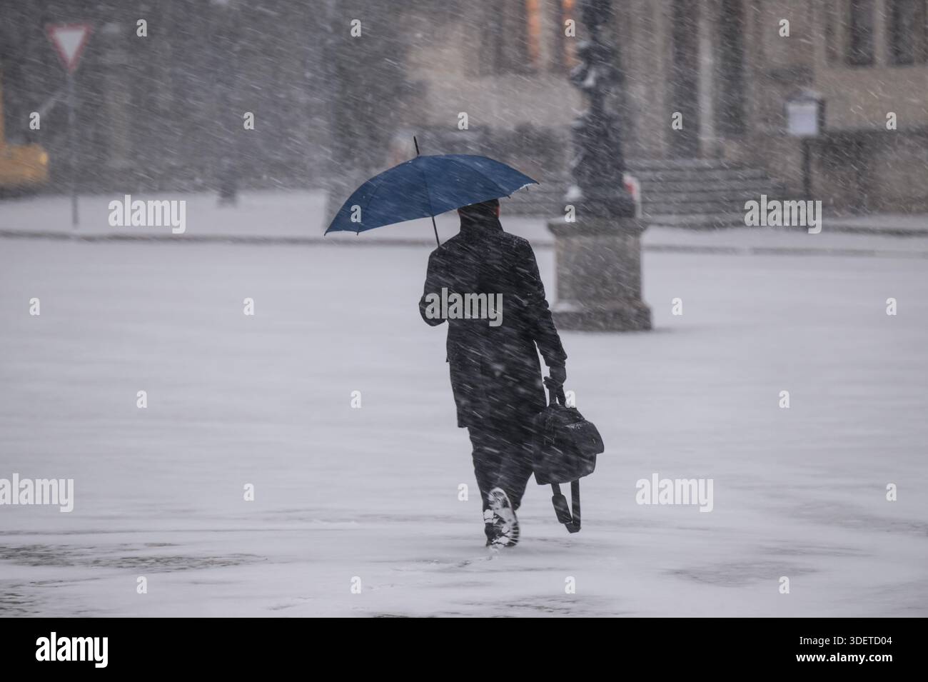 Dresden, Germany. 09th Jan, 2026. A man with an umbrella walks across ...