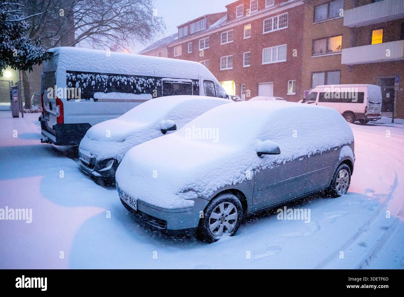 09 January 2026, Bremen: Snow-covered cars in a parking lot. Lots of ...