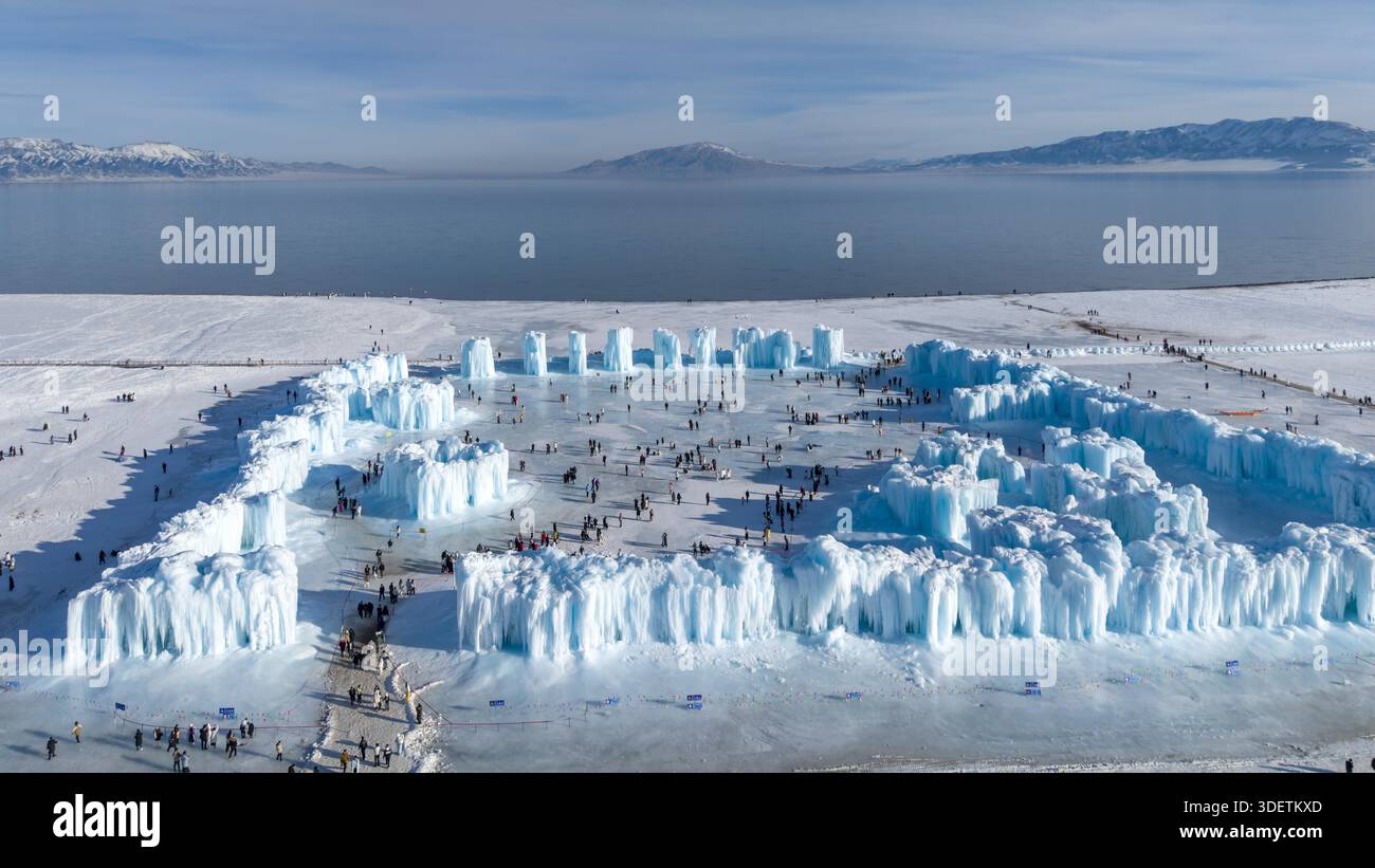 Tourists visit the blue ice waterfalls formed by frozen lake water at ...