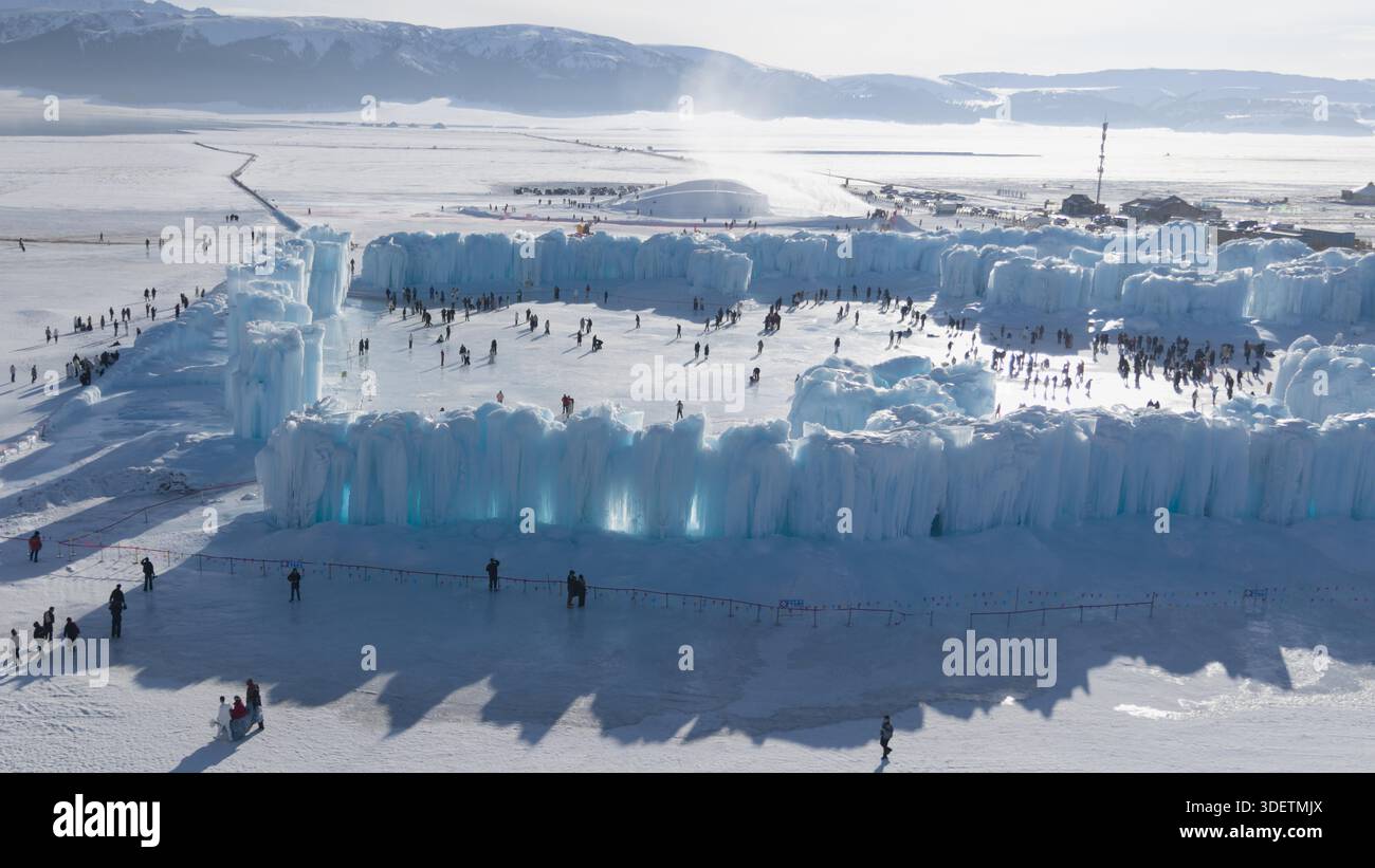 Tourists visit the blue ice waterfalls formed by frozen lake water at ...