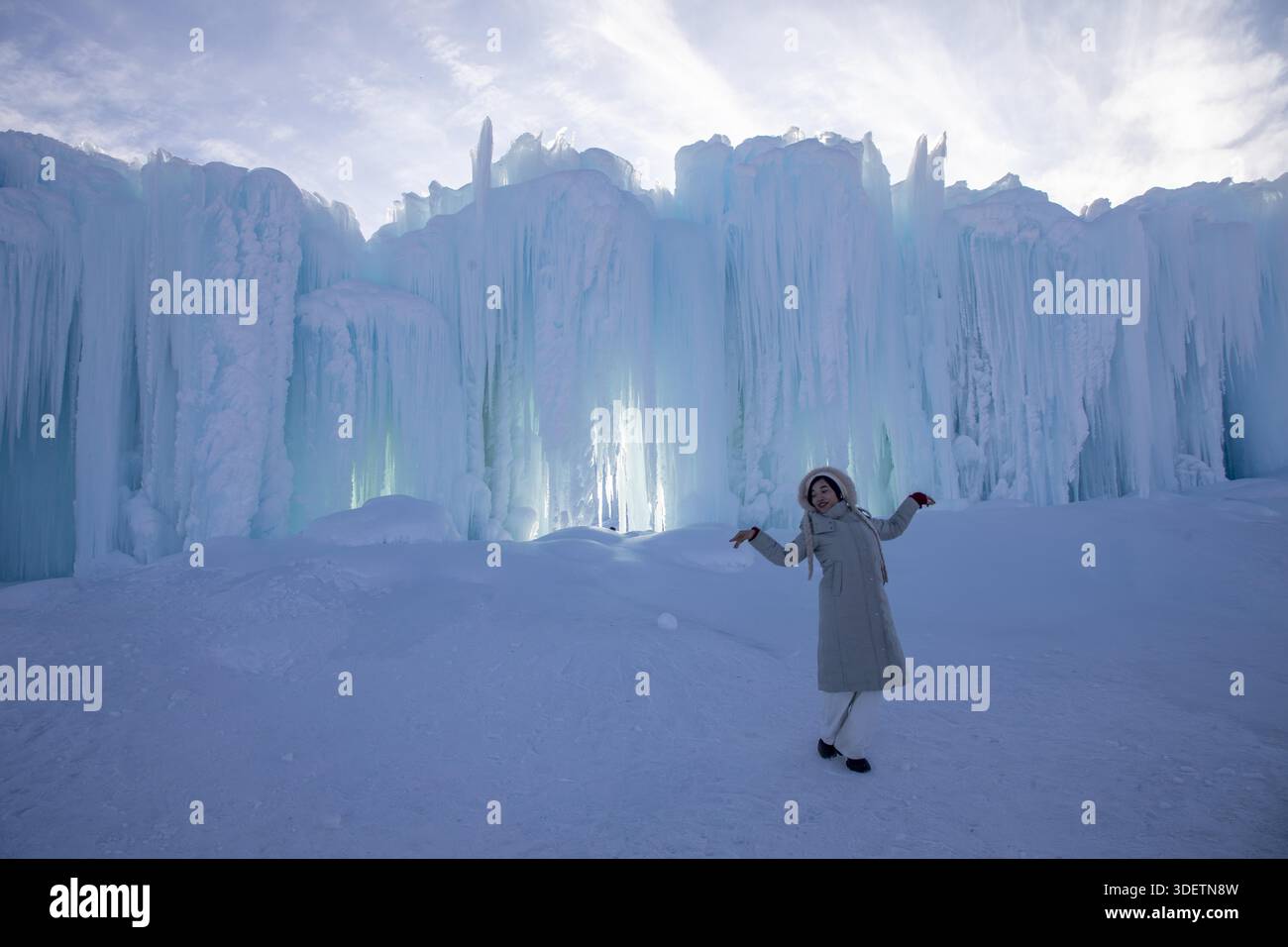 Tourists visit the blue ice waterfalls formed by frozen lake water at ...