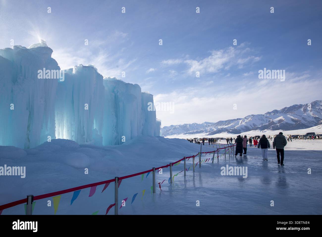 Tourists visit the blue ice waterfalls formed by frozen lake water at ...