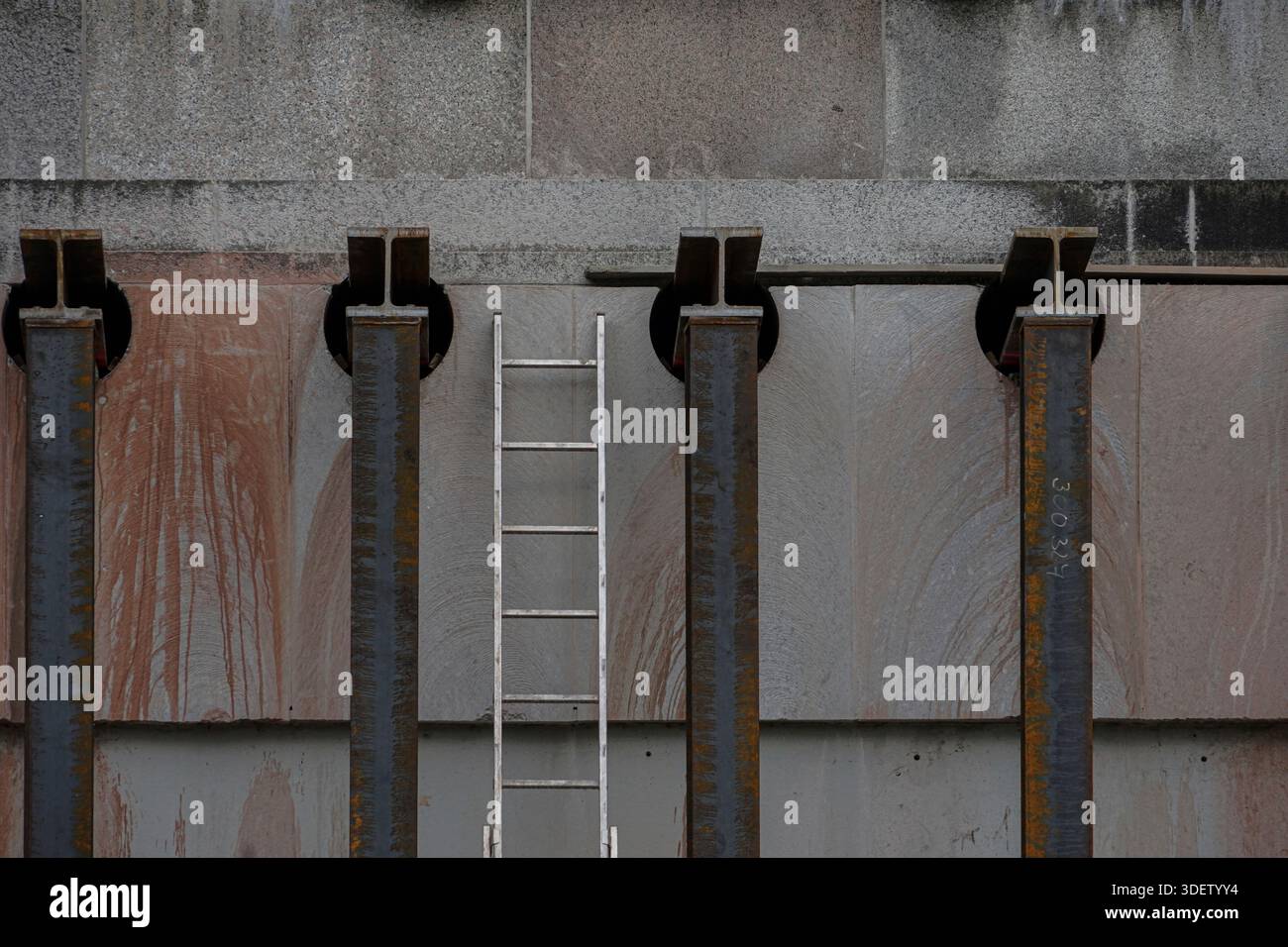Steel beams and a metal ladder stand against a weathered industrial ...