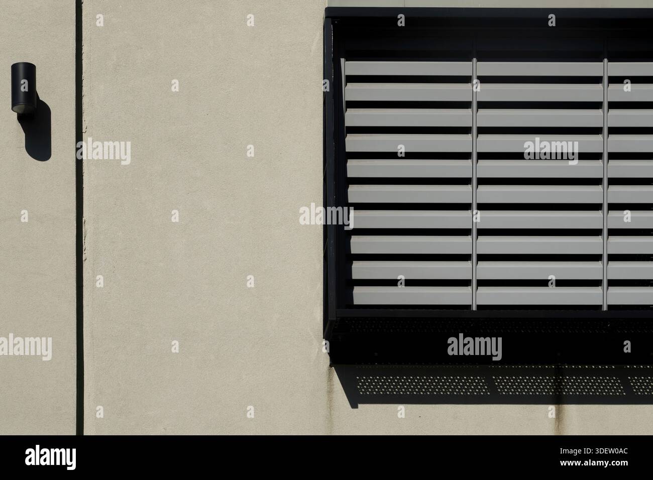 Minimalist building facade featuring a black wall light and horizontal ...