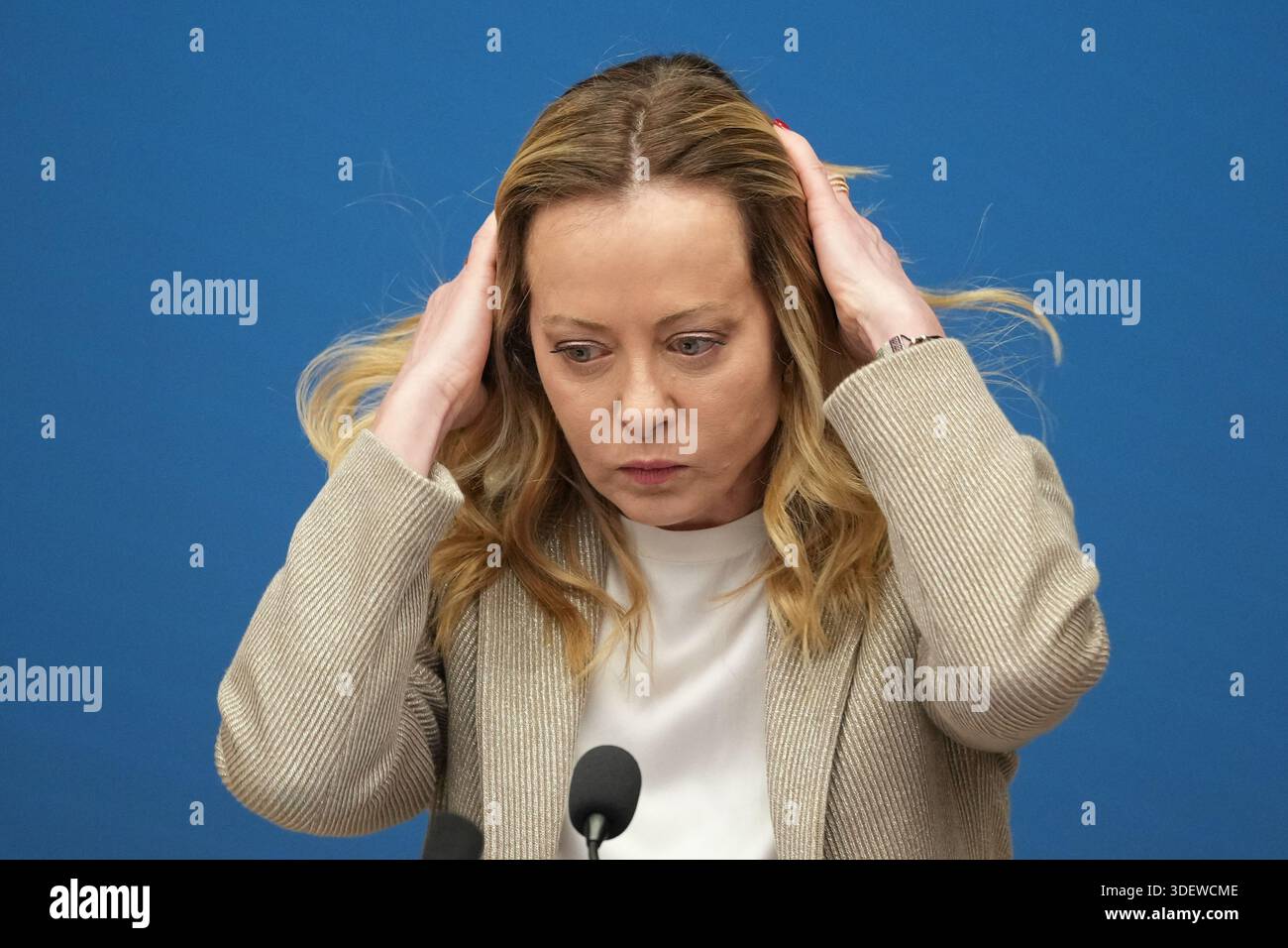 Italian Premier Giorgia Melon pulls back her hair during beginning of ...