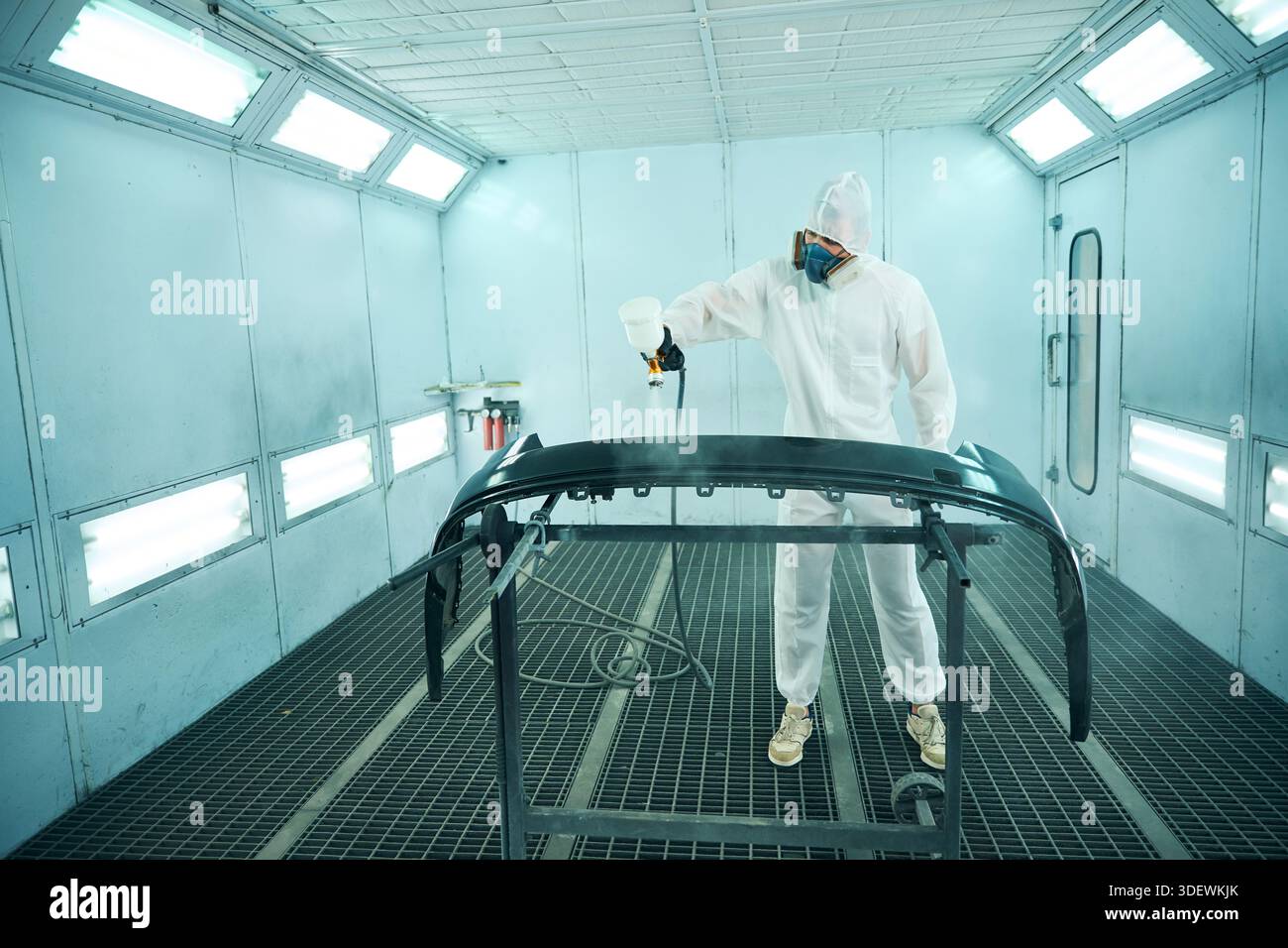 Worker wearing costume and protective gear while painting parts of the ...