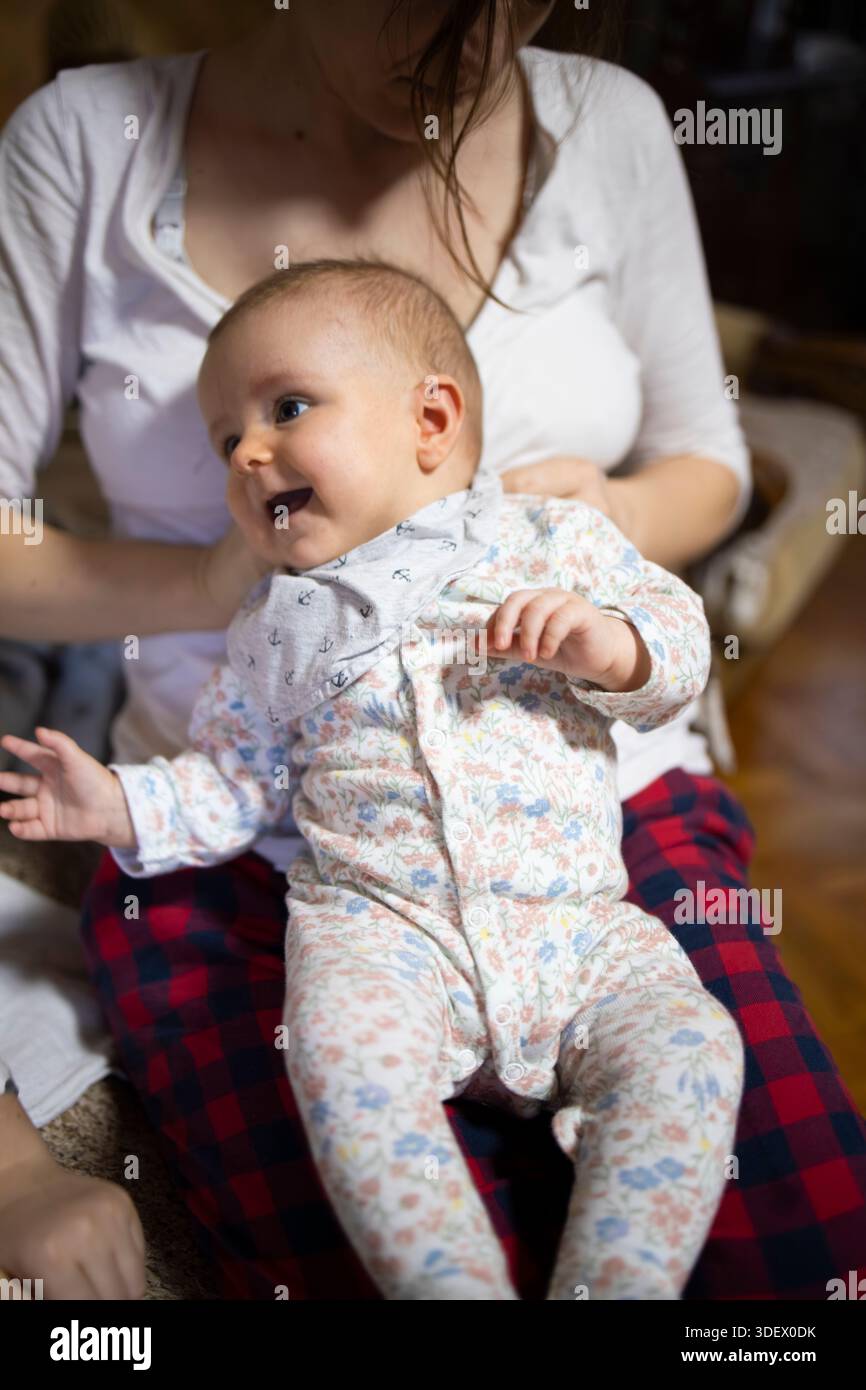 Caring mother dressing baby hi-res stock photography and images - Alamy