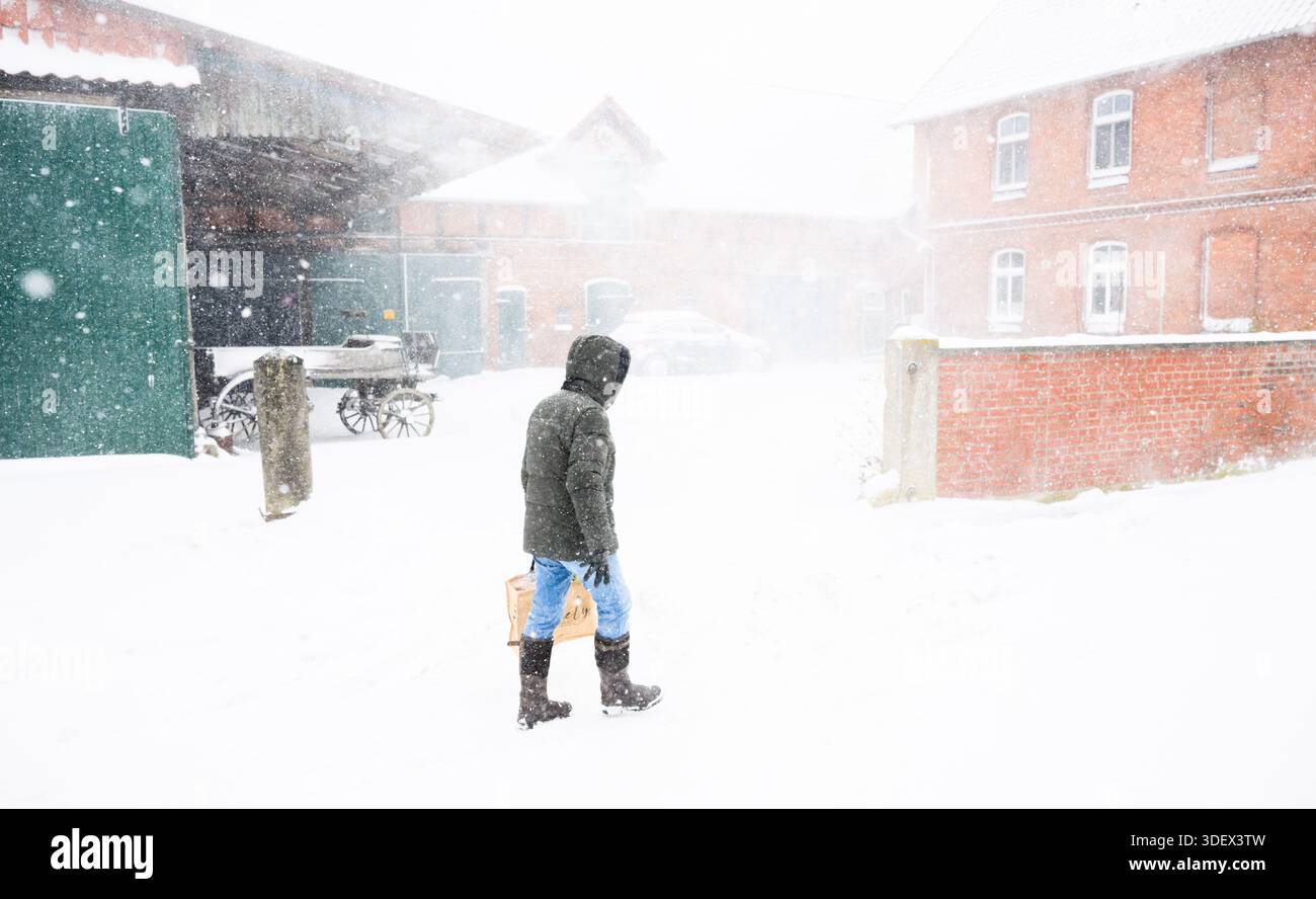 09 January 2026, Lower Saxony, Laatzen: A man walks past a farm in the ...