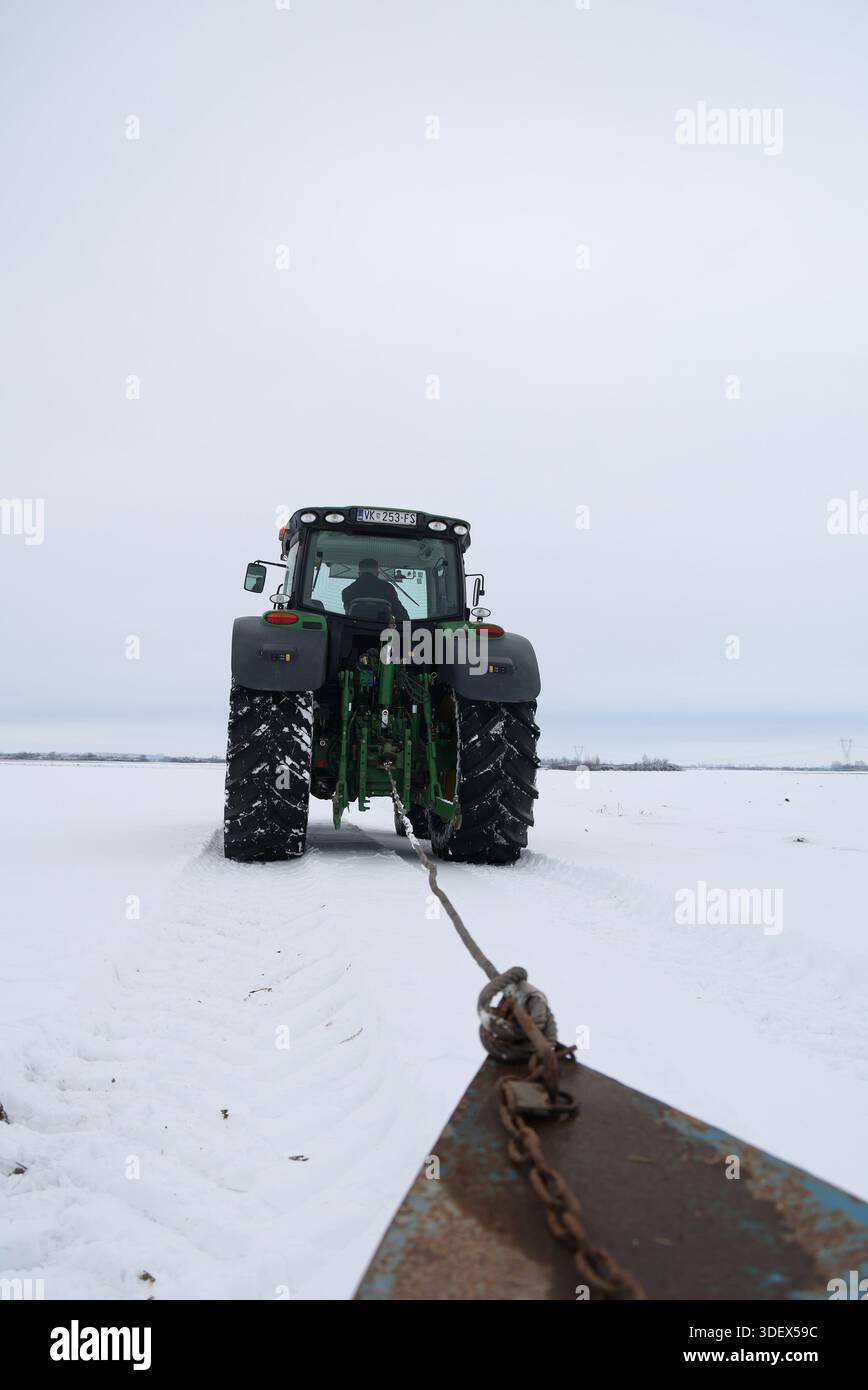 A tractor pulls people on a boat sled at snow covered field in Vinkovci ...