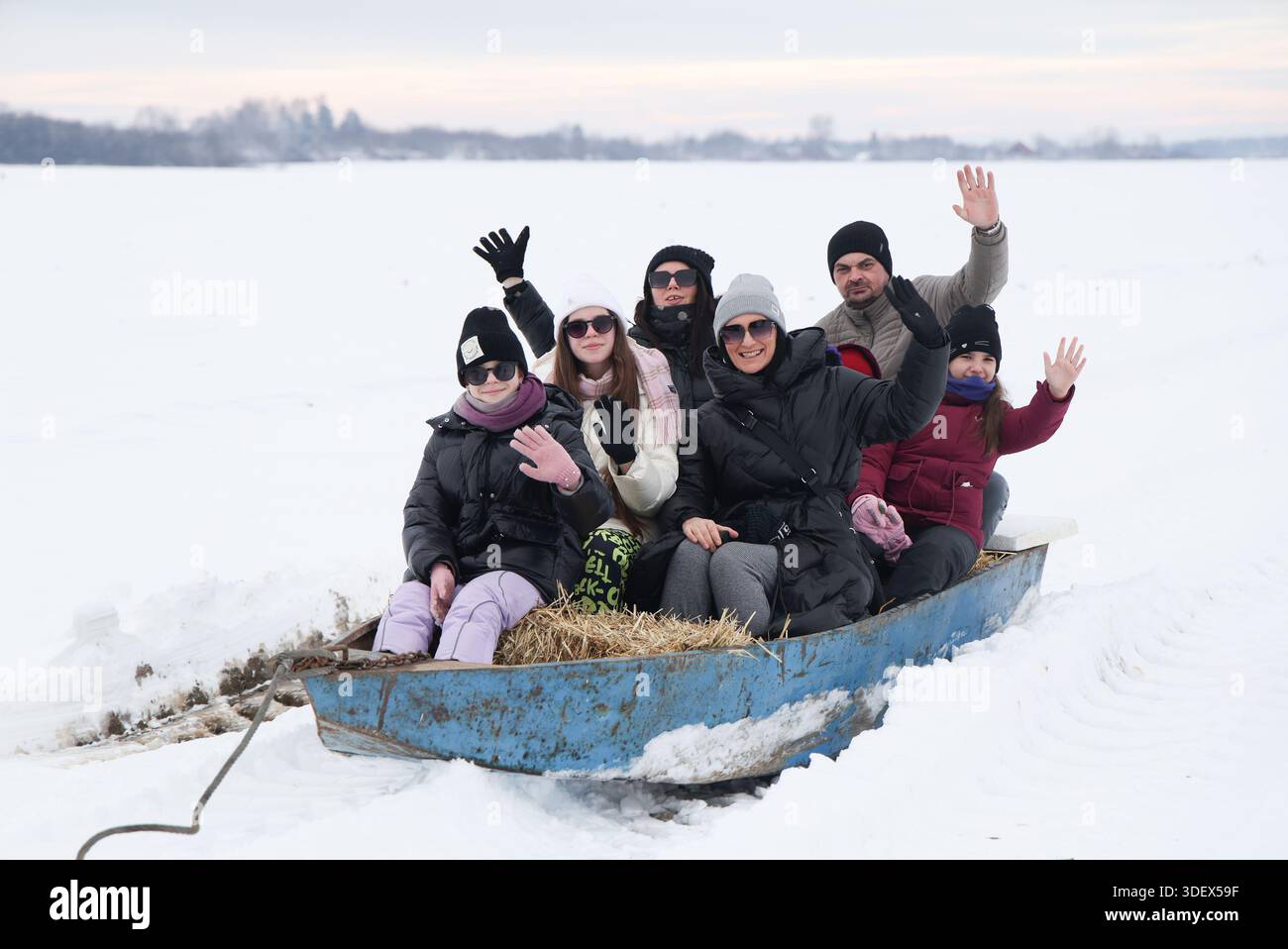 A tractor pulls people on a boat sled at snow covered field in Vinkovci ...