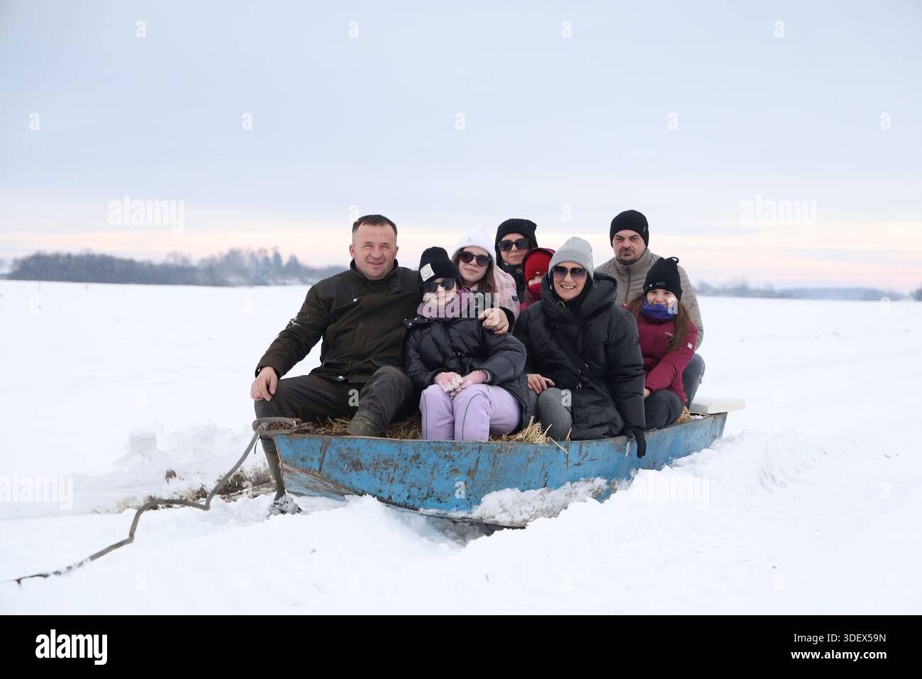 A tractor pulls people on a boat sled at snow covered field in Vinkovci ...