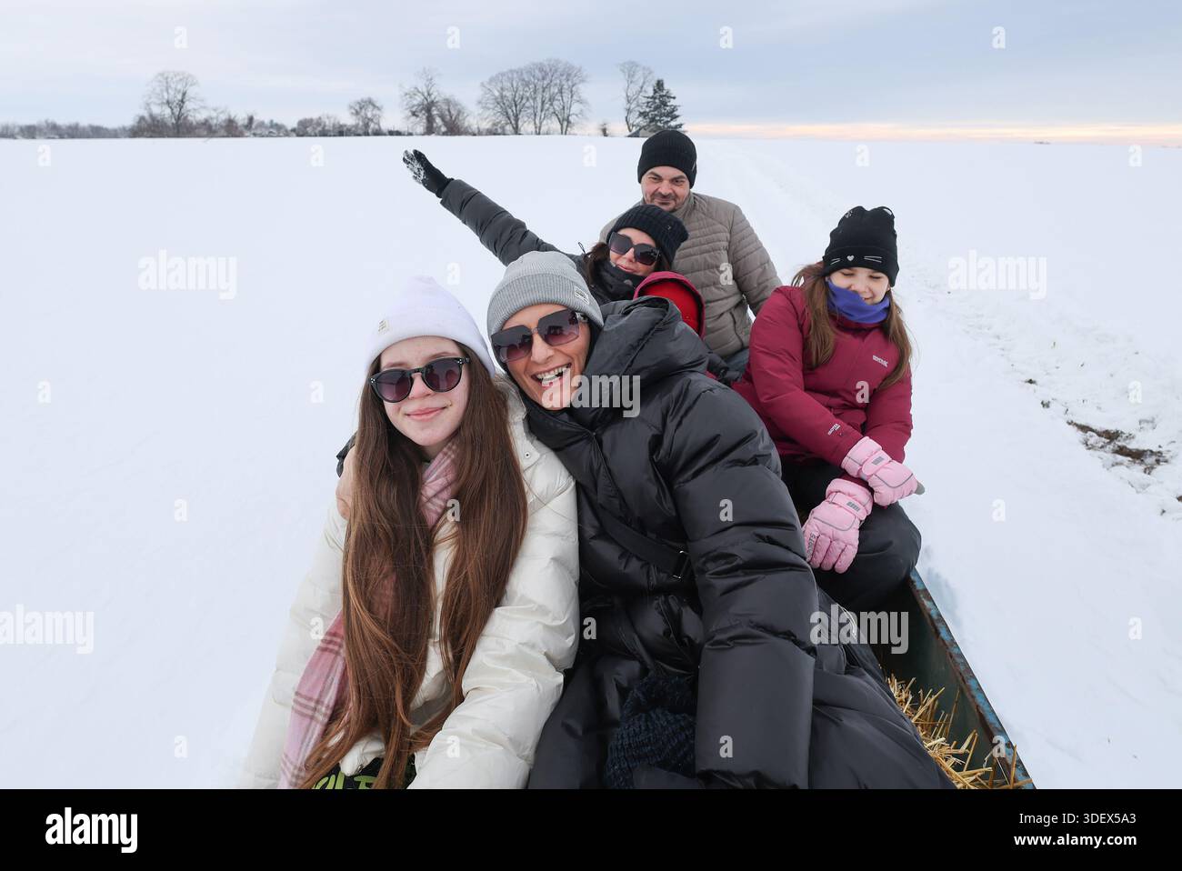 A tractor pulls people on a boat sled at snow covered field in Vinkovci ...