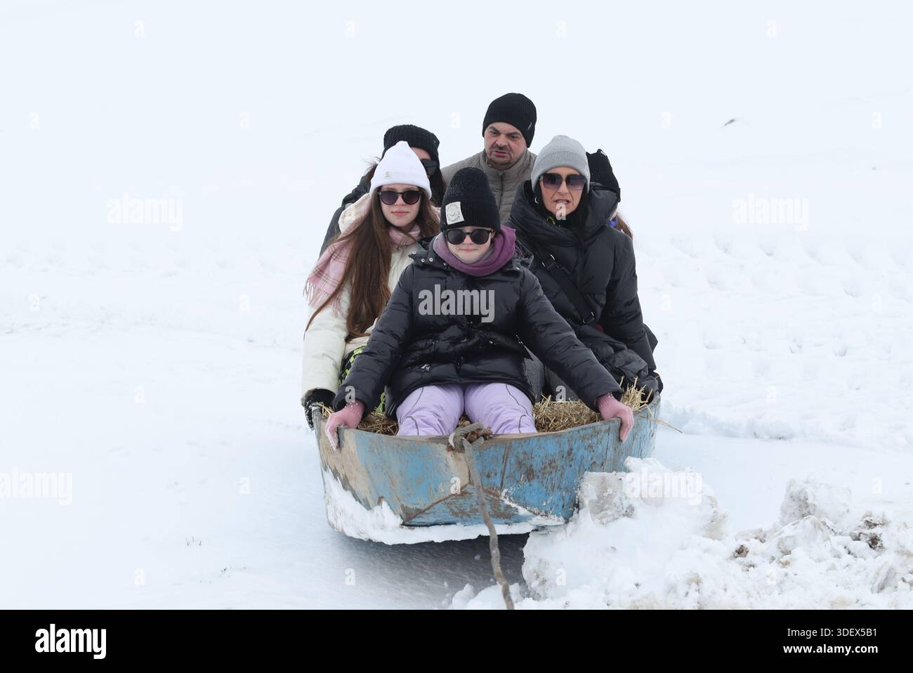 A tractor pulls people on a boat sled at snow covered field in Vinkovci ...