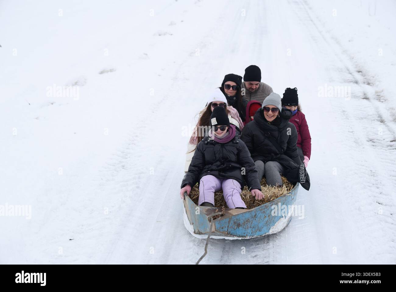 A tractor pulls people on a boat sled at snow covered field in Vinkovci ...