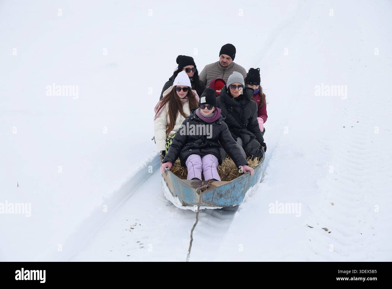 A tractor pulls people on a boat sled at snow covered field in Vinkovci ...